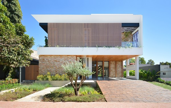 Casa de 538 m² é marcada por madeira, brises metálicos e paisagismo