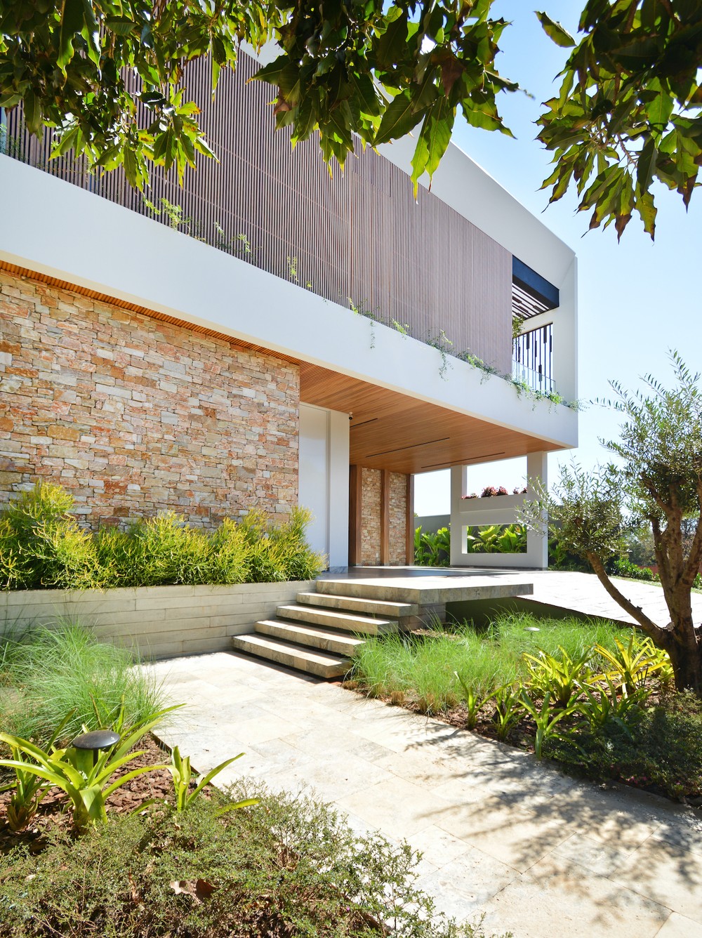 Casa de 538 m² é marcada por madeira, brises metálicos e paisagismo