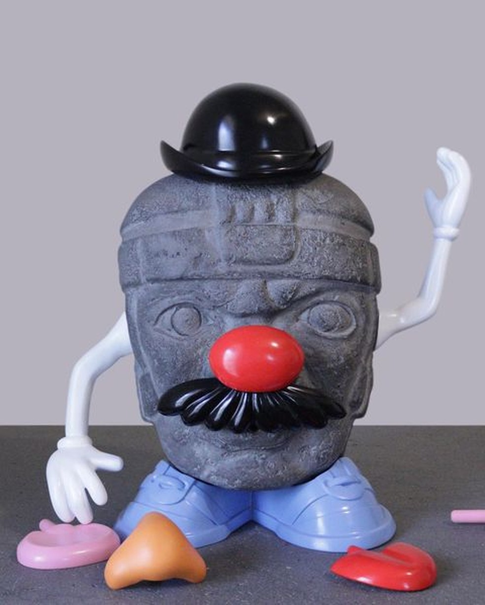 Artista esmaga carro Tesla com escultura colossal de cabeça olmeca