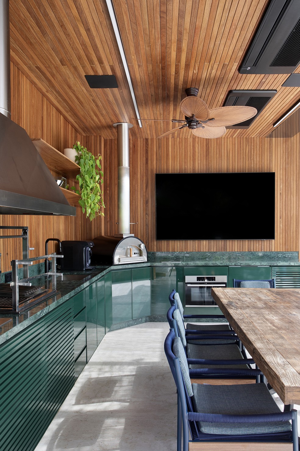 Terraço de cobertura no RJ tem área gourmet com muito verde e madeira