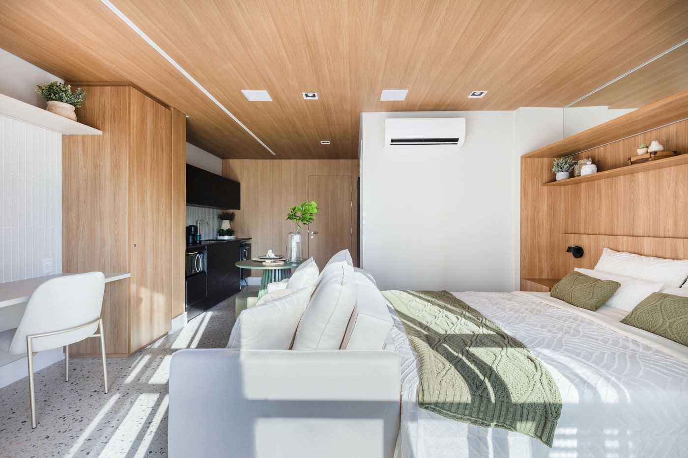 Madeira e granilite conferem aconchego e unidade visual a apê de 25 m²