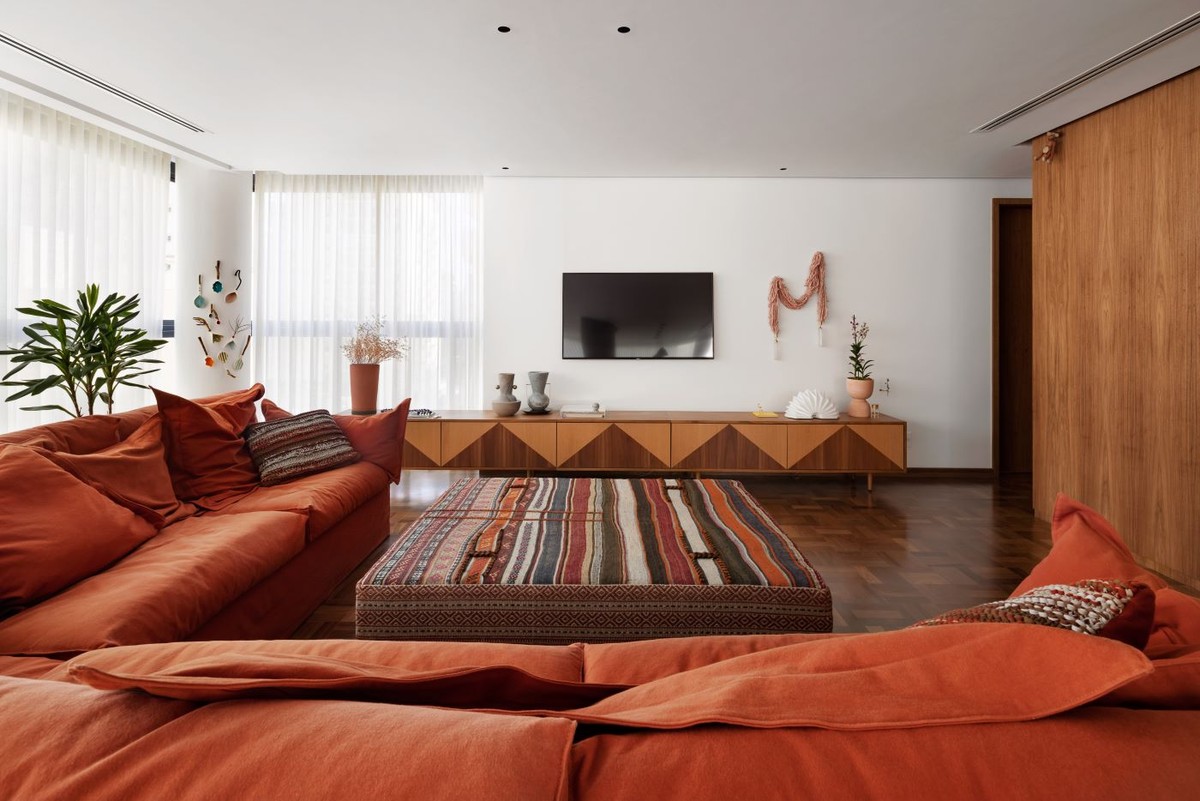 Madeira e cores vibrantes guiam projeto de apartamento modernista