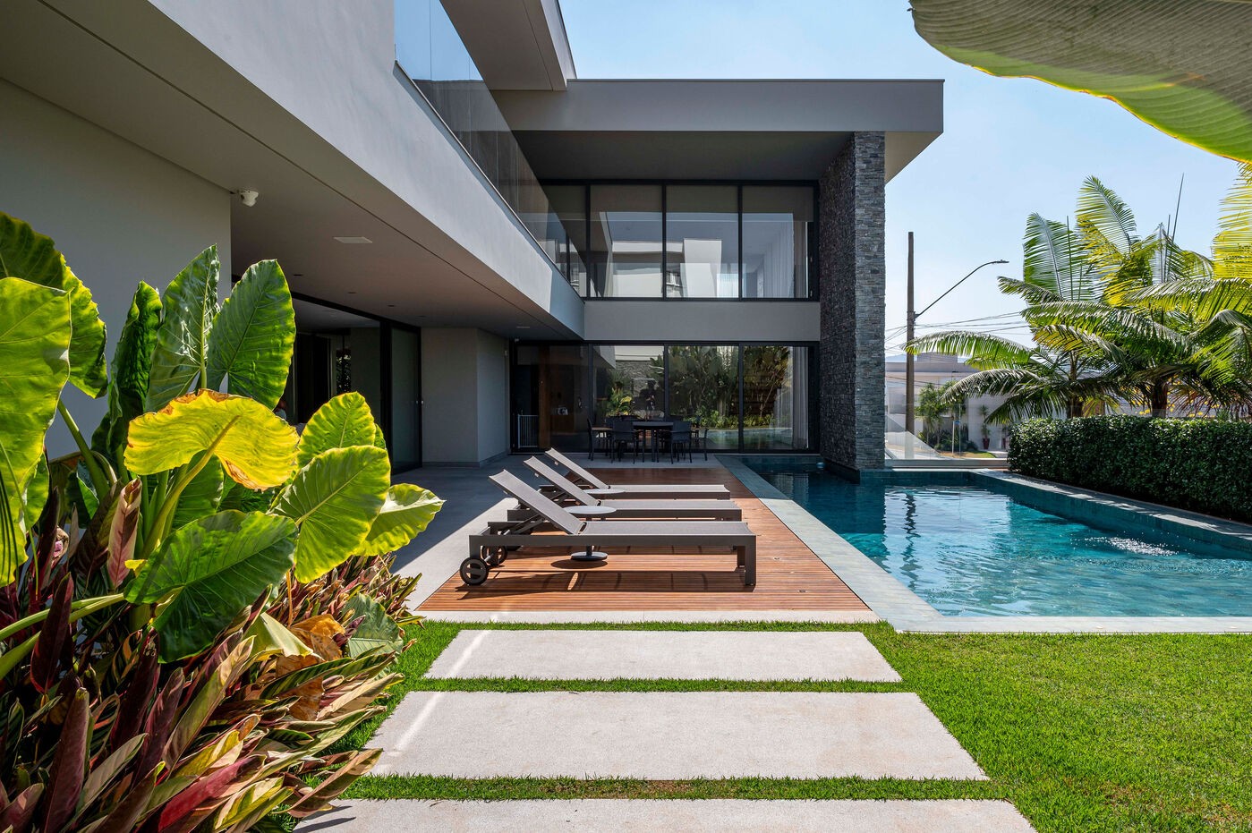 Plantas tropicais e canteiros orgânicos suavizam linhas retas em casa ...