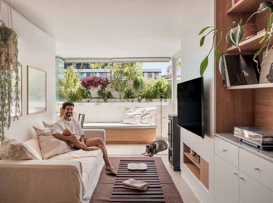 Apartamento de 130 m² em SC integra interiores a pátio com muitas plantas