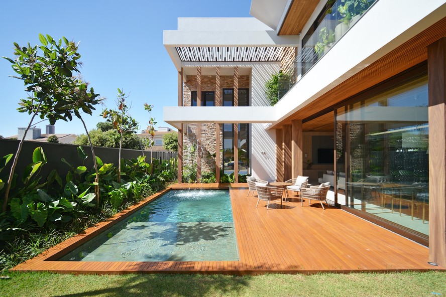 Casa de 538 m² é marcada por madeira, brises metálicos e paisagismo