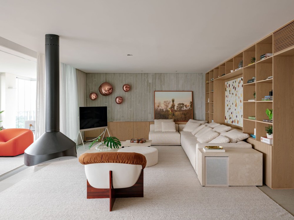 Apartamento tem sala de estar com mix de poltronas coloridas e lareira ...