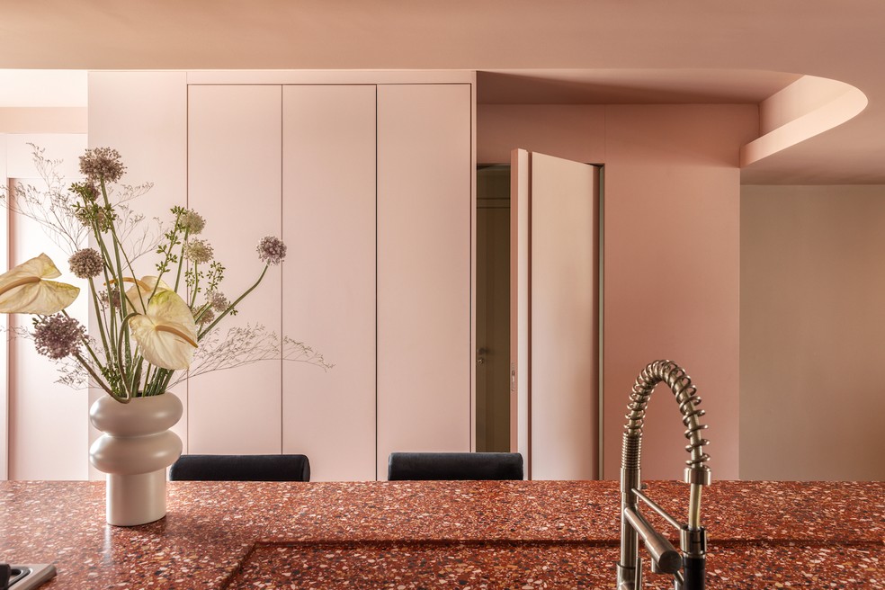 Curvas evidenciam decoração suave e cozinha cor-de-rosa de apartamento