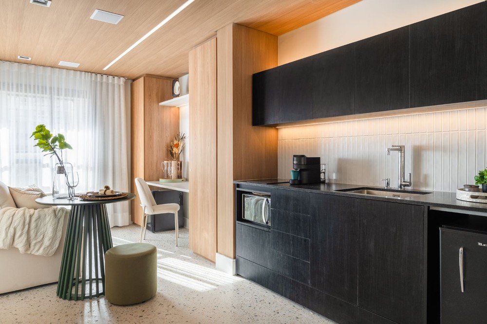 Madeira e granilite conferem aconchego e unidade visual a apê de 25 m²