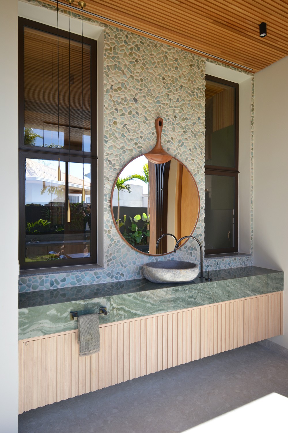 Casa de 538 m² é marcada por madeira, brises metálicos e paisagismo