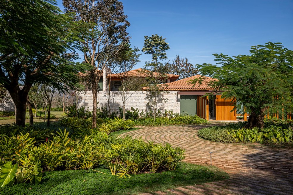 Reforma de casa em condomínio valoriza natureza e cria um novo volume
